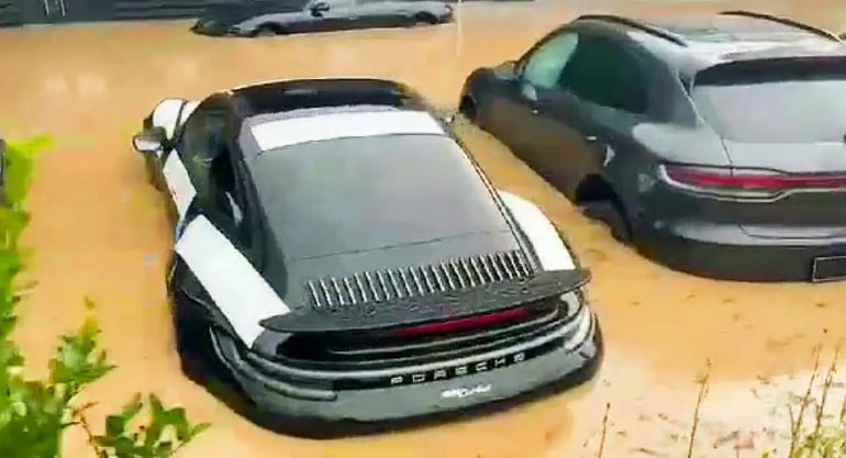 Dozens of brand new Porsches are seen floating in water at a German ...
