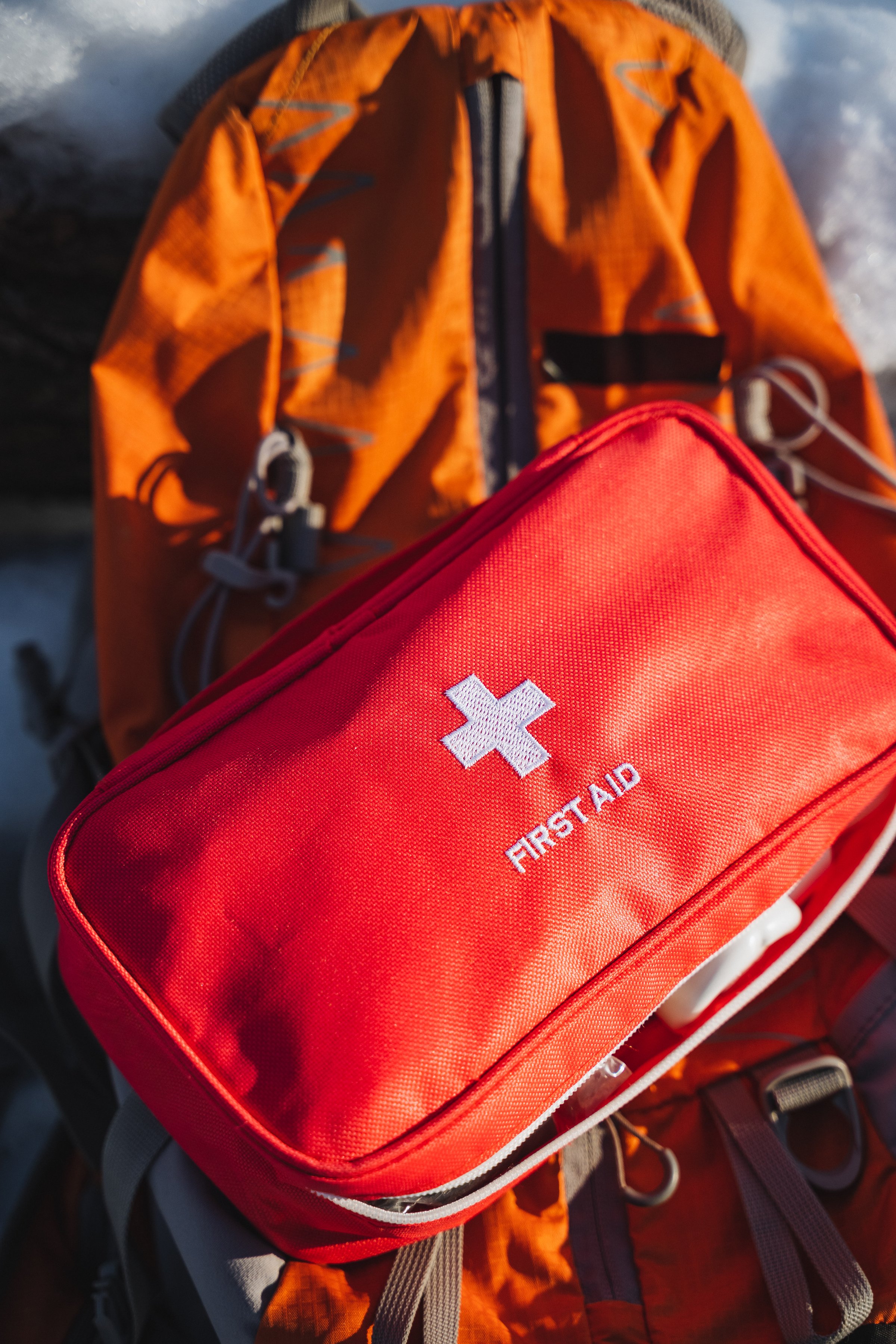 A bright red first aid bag is currently resting on top of an ...